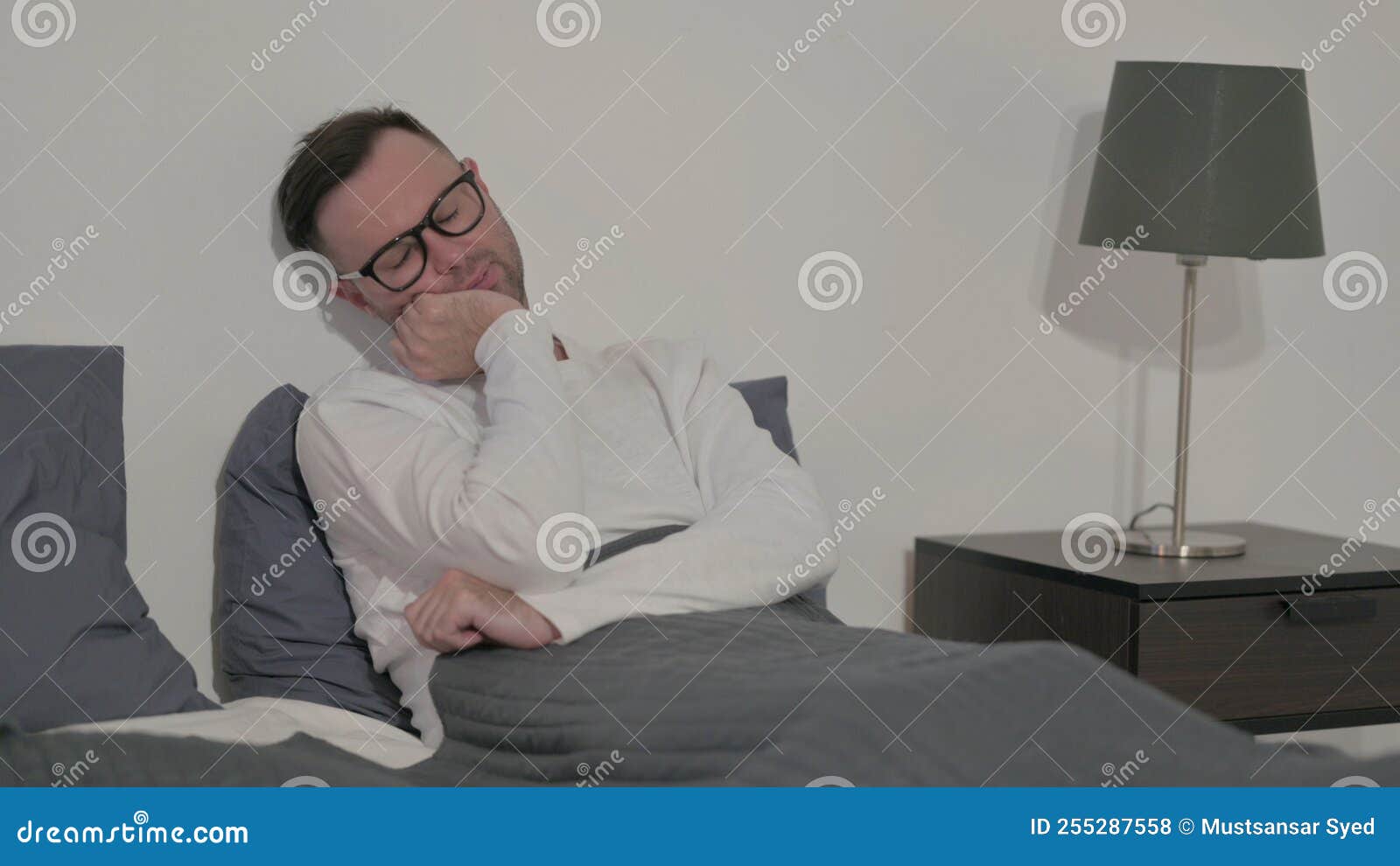 Sleepy Casual Man Taking Nap while Sitting in Bed Stock Photo - Image ...