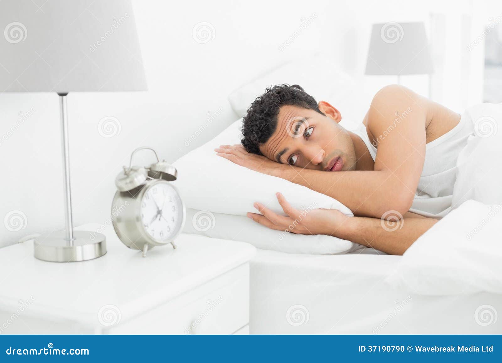 Sleepy Man Looking at the Alarm Clock in Bed Stock Photo - Image of ...