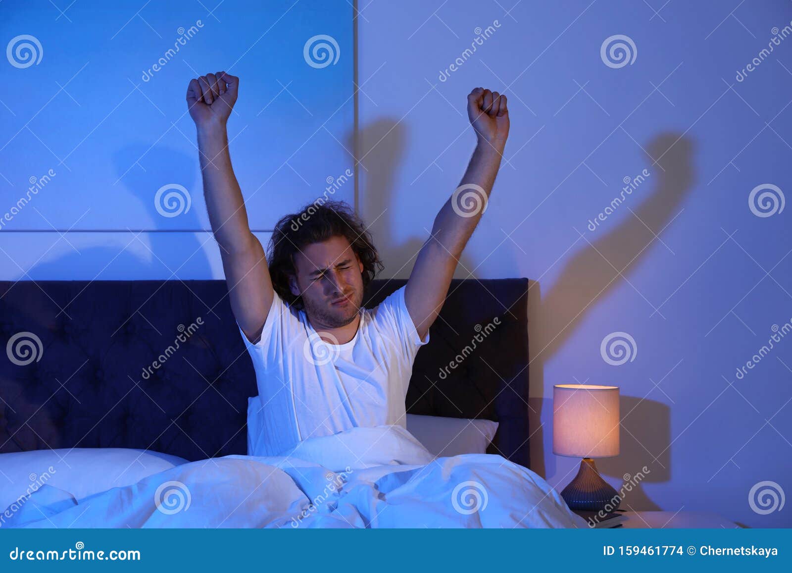 Sleepy Young Man Stretching in Dark Room at Night Stock Photo - Image ...