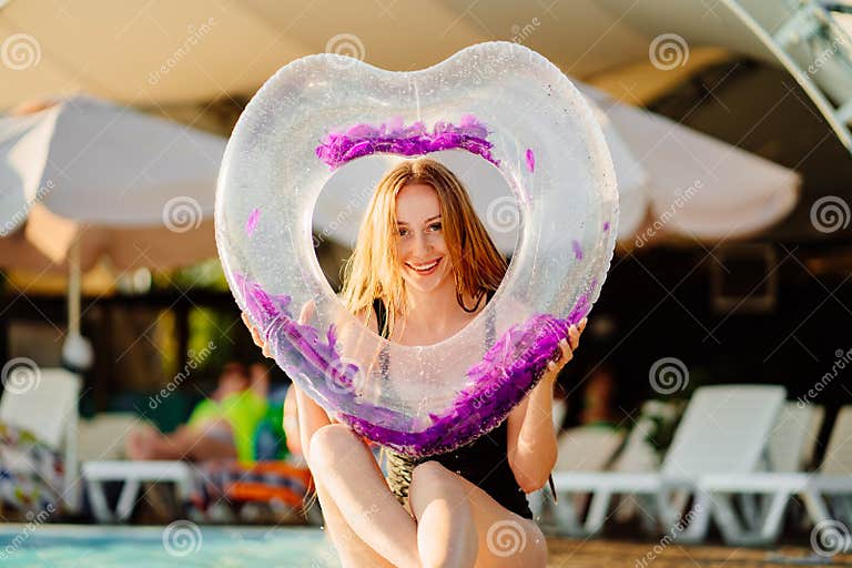 A Slender Woman With Swimming Circle Sits On The Side Of The Pool Stock Image Image Of