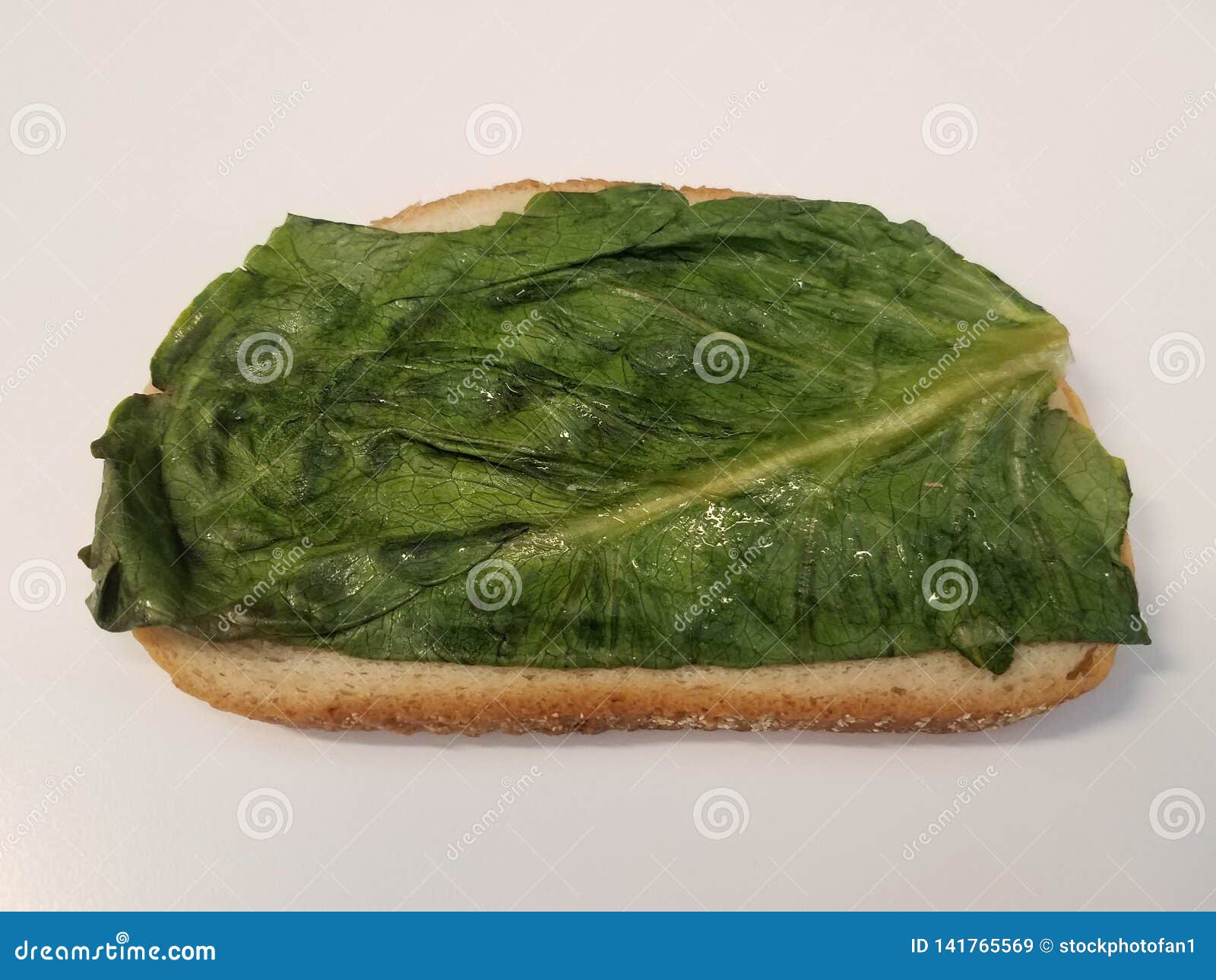 Slice of Bread on White Surface with Leafy Green Lettuce Stock Image ...
