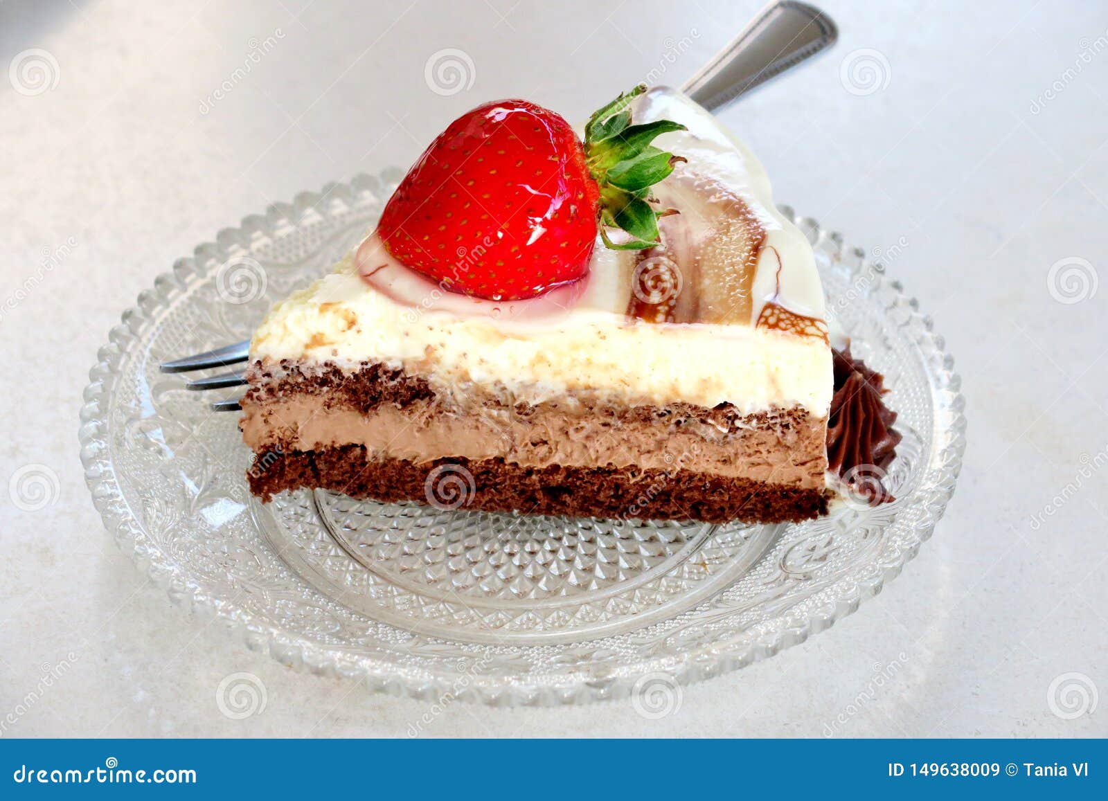 A Slice of Cake of Three Different Layers with Strawberries on a Small ...
