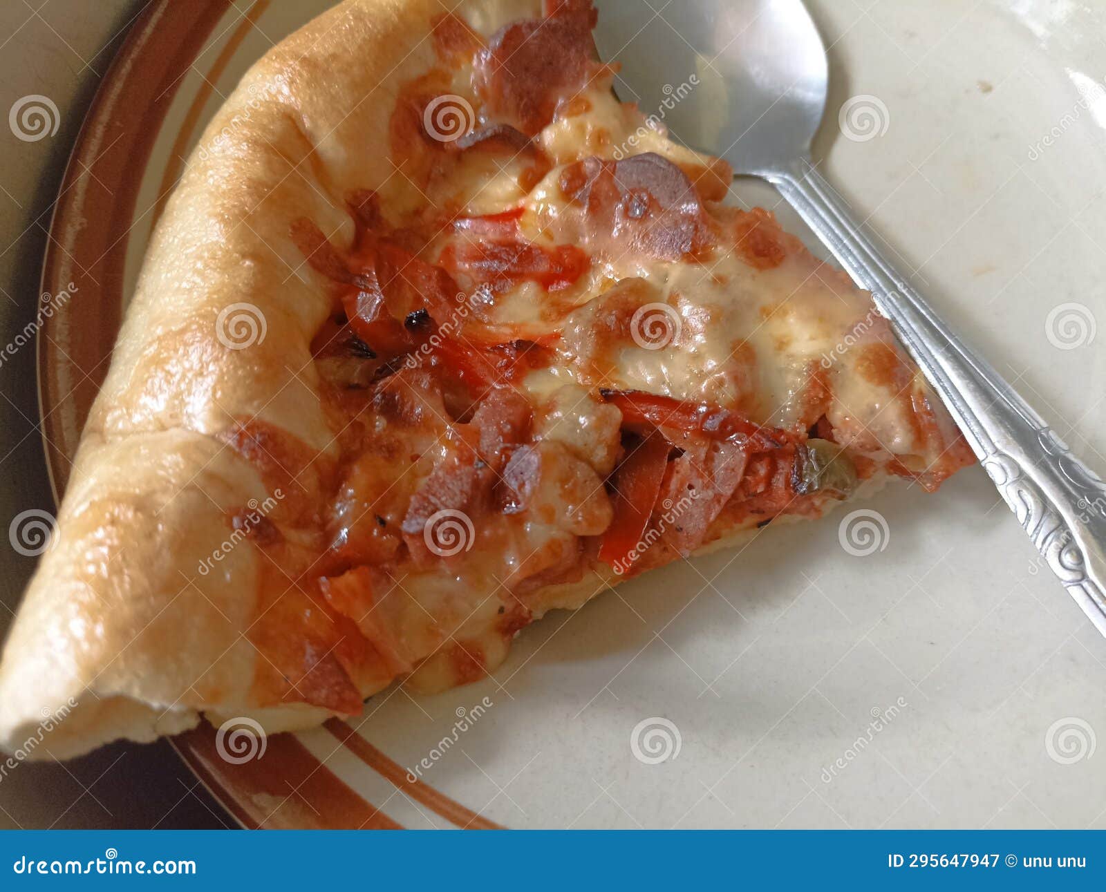 A Slice of Delicious and Warm Pepperoni Pizza with a Spoon Next To it ...