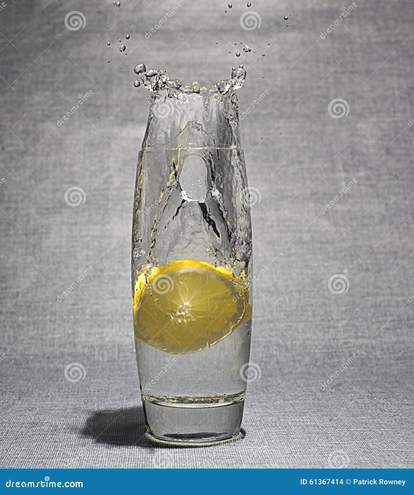 Slice of Lemon Dropped in Glass of Water Stock Photo - Image of drops ...