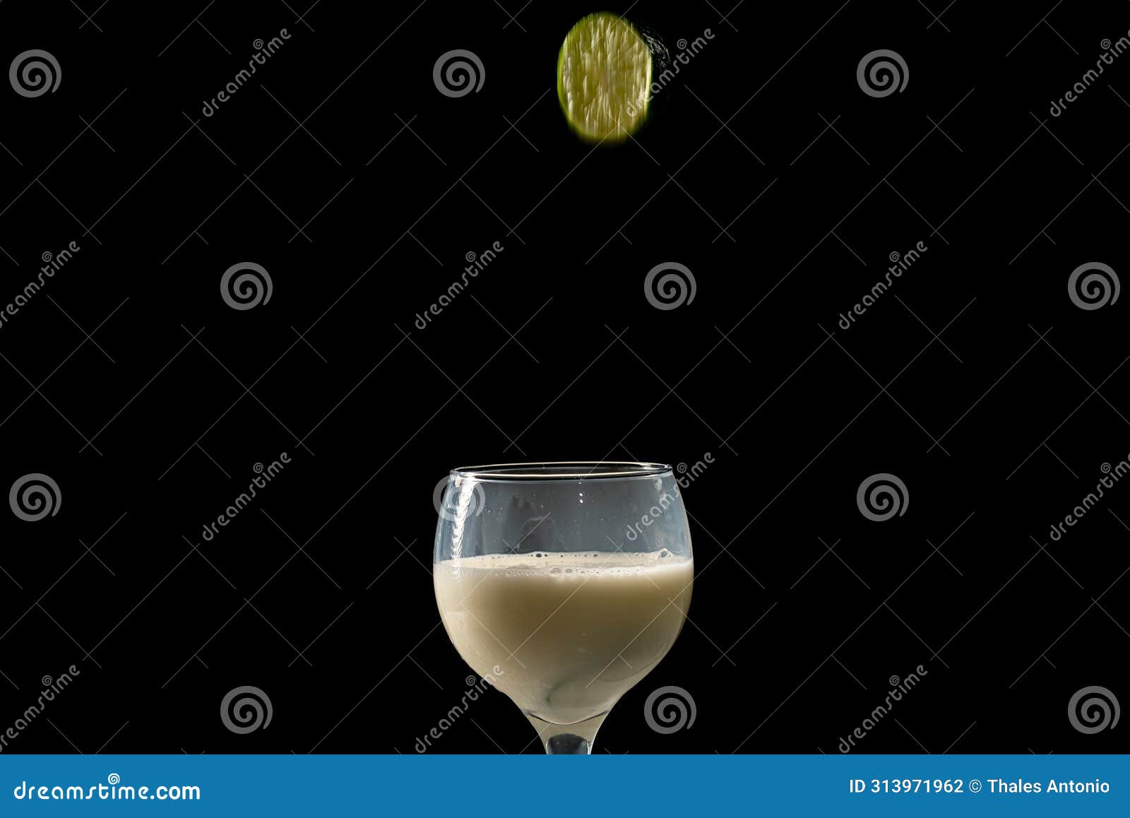A Slice of Lemon Falling into a Glass Cup with Milk Inside Stock Photo ...