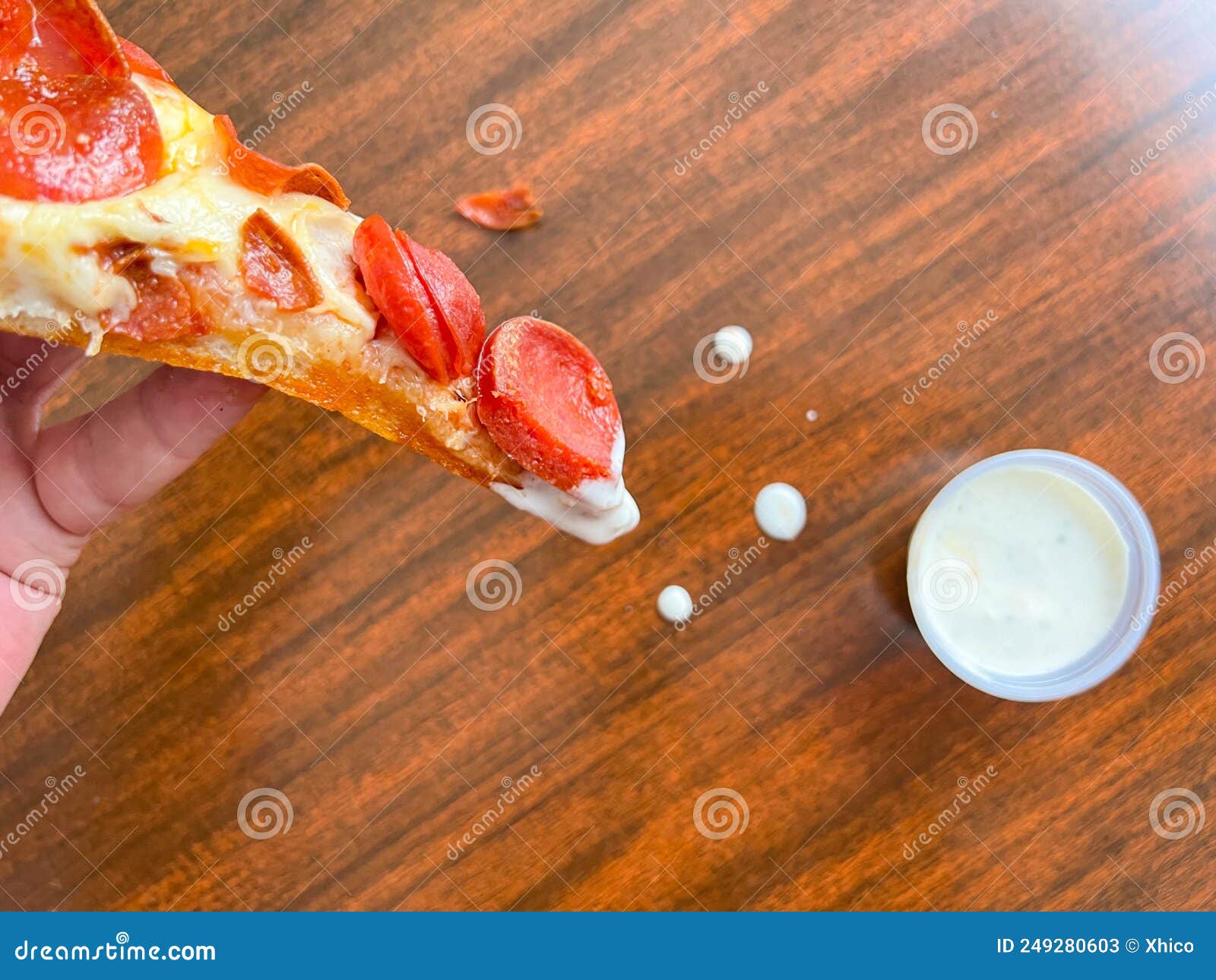 A Slice of Pepperoni Pizza Being Dipped into Ranch Dressing Stock Image ...