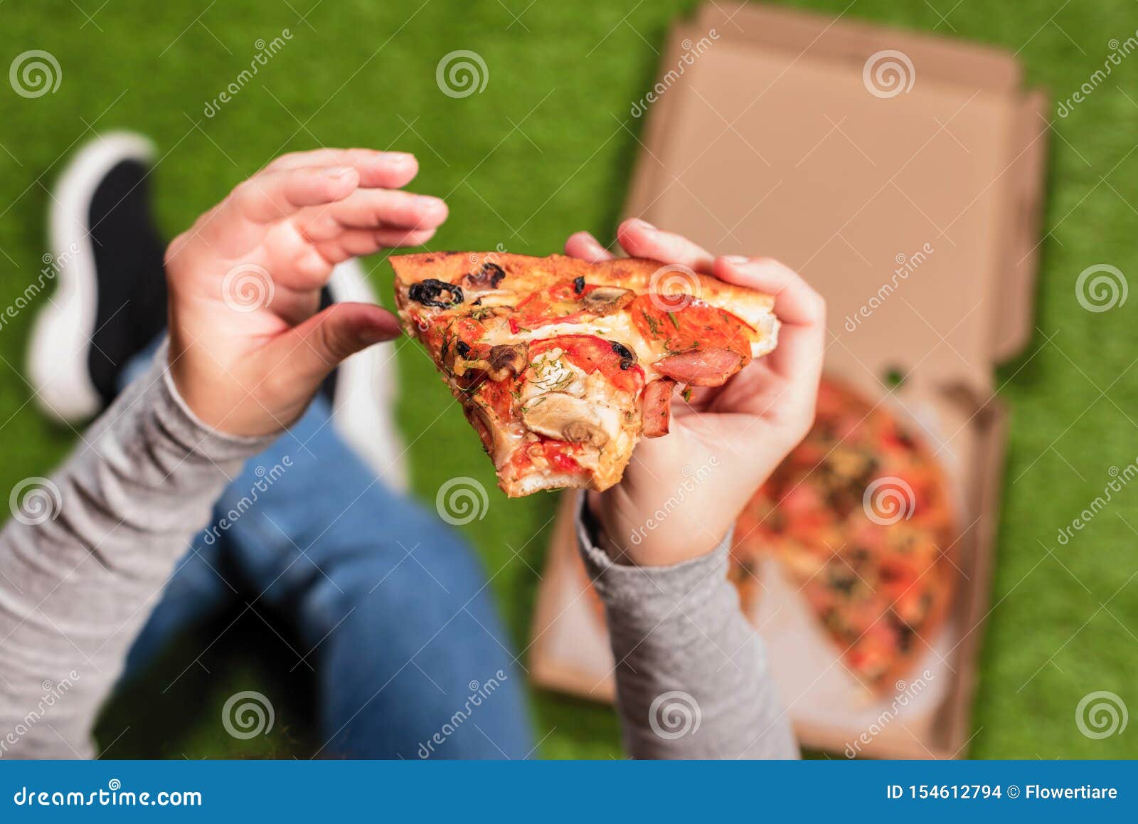 A Slice of Pizza in Female Hands. Lunch on the Green Grass. Stock Photo ...
