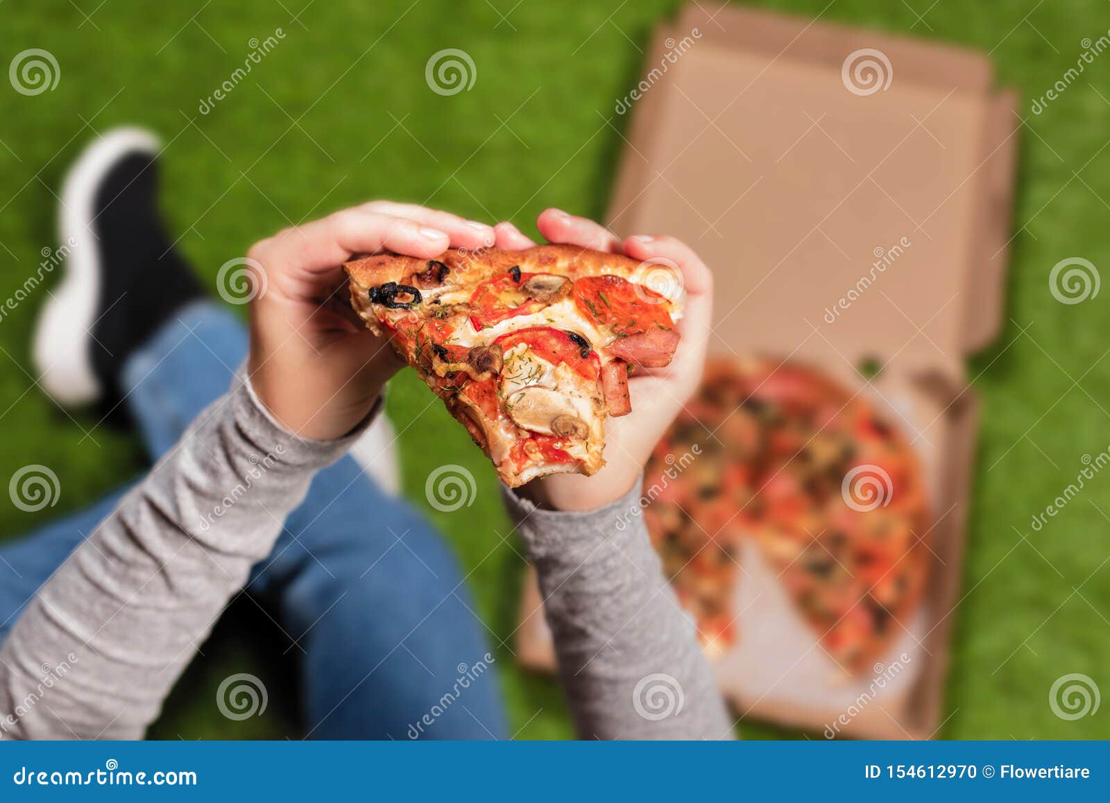 A Slice of Pizza in Female Hands. Lunch on the Green Grass Stock Photo ...