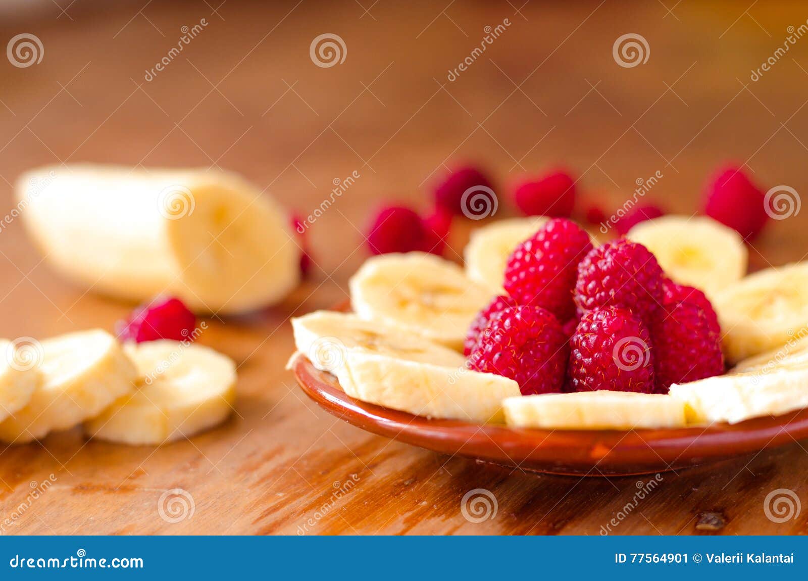 Sliced Banana with Raspberries on the Brown Plate. Horizontal, Top View ...