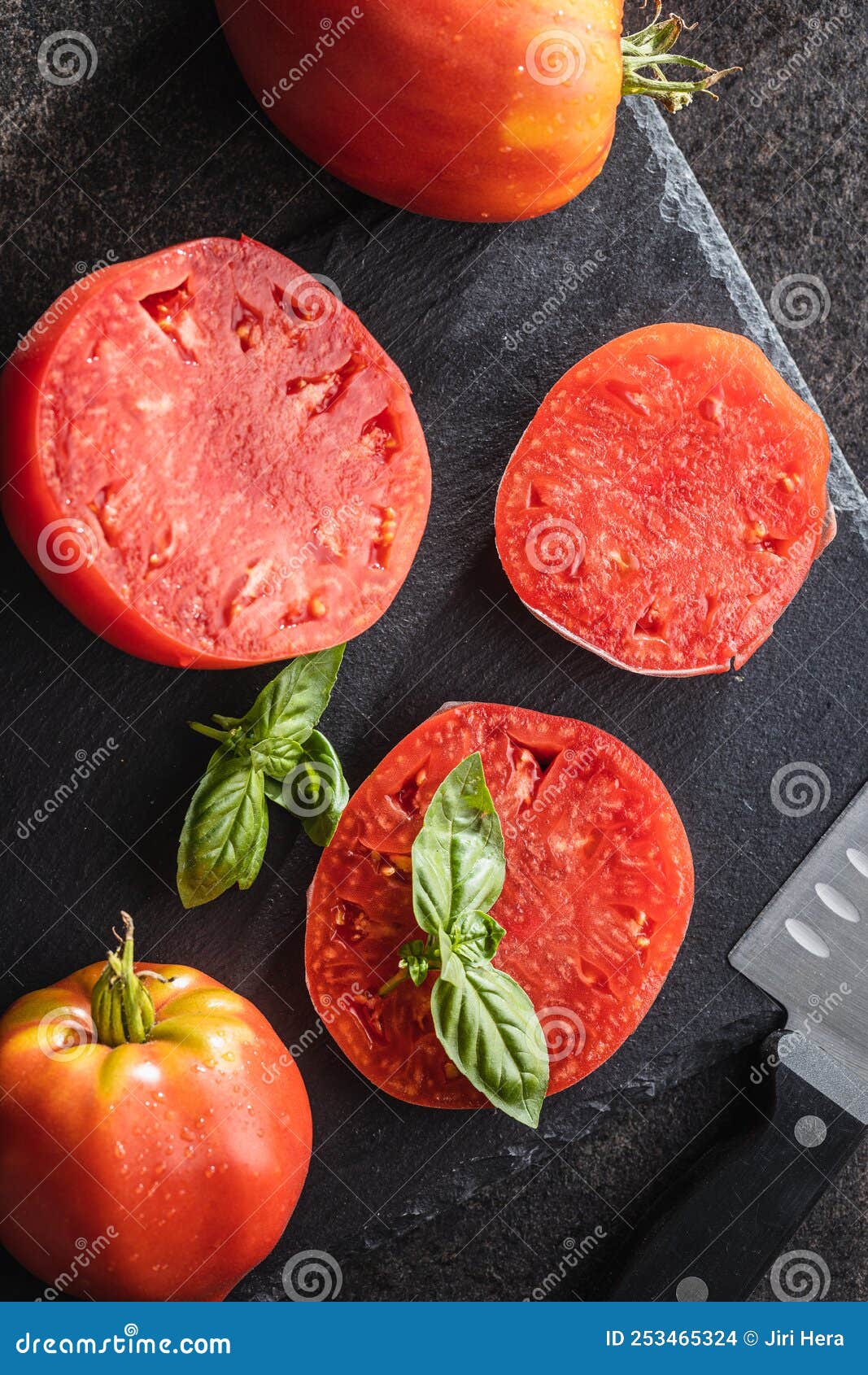 Sliced Bull Heart Tomatoes on Black Table Stock Photo - Image of basil ...