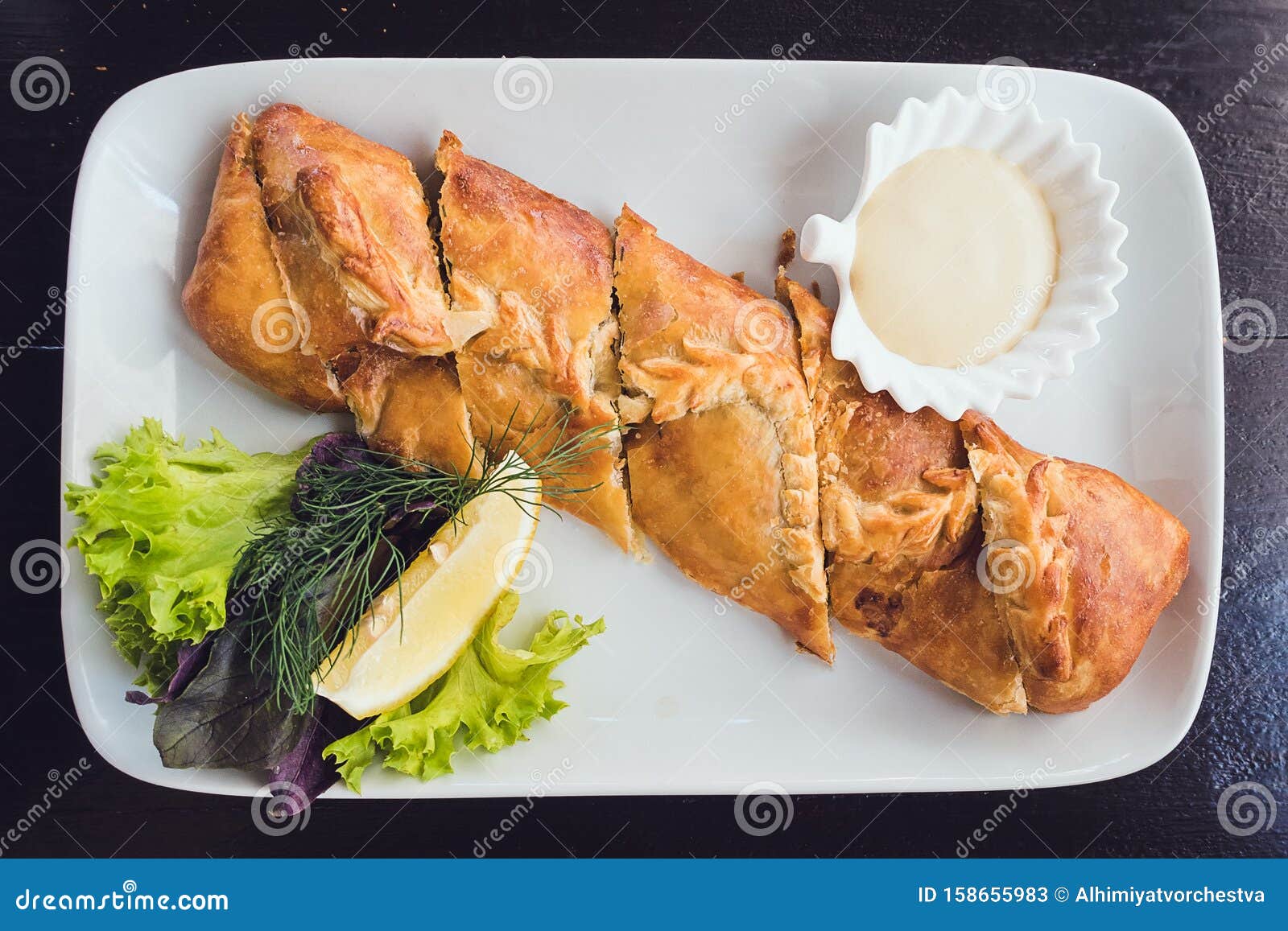 Sliced Puff Pastry Roll on a Rectangular Plate, Garnished with Greens ...