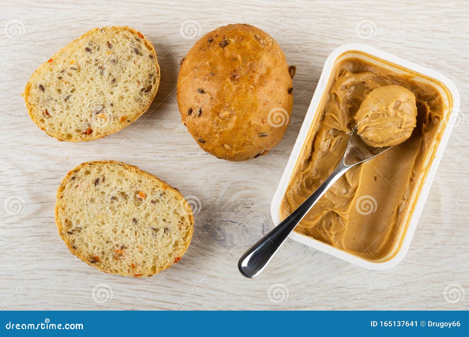 Slices of Bread, Bun, Container with Peanut Butter and Spoon on Table ...