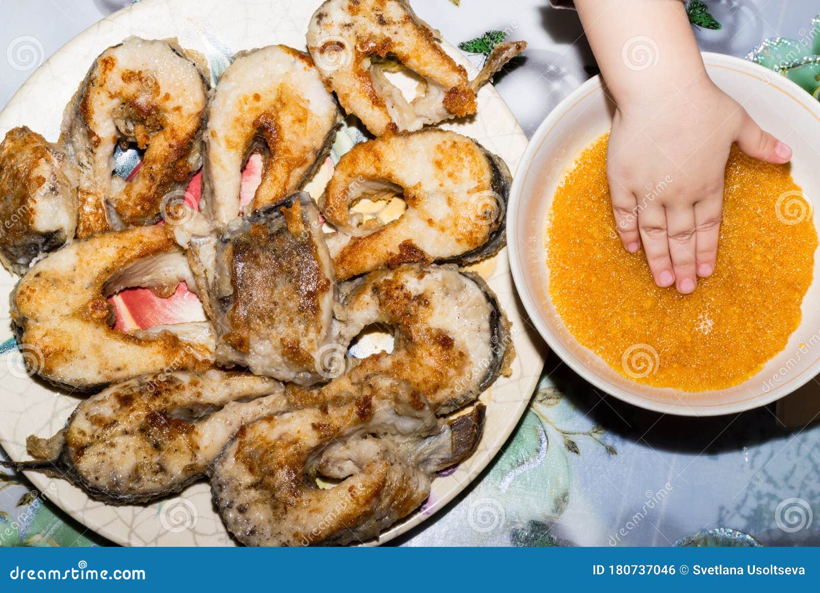Slices of Fried Fish Cooked at a Rustic Dinner, Caviar in a White Plate. the Child Pulls His ...