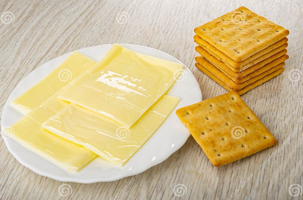 Slices of Melted Cheese in Plate, Stack of Crackers on Table Stock ...