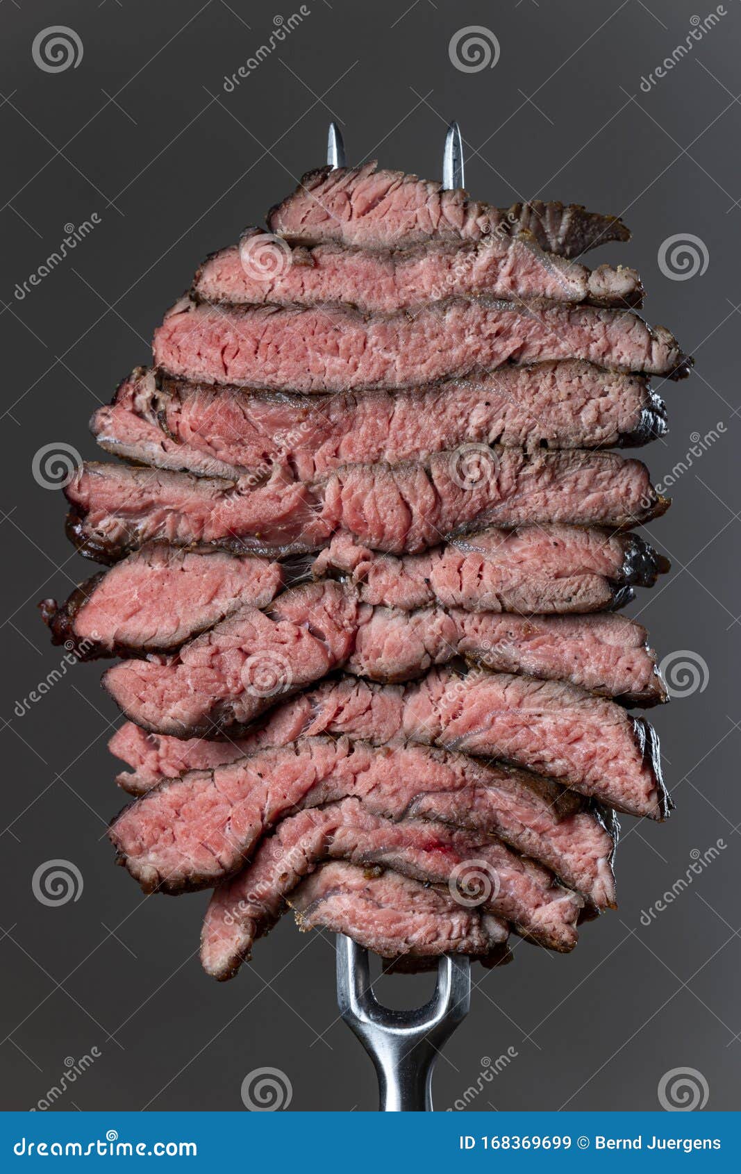 Slices of a steak on grey stock image. Image of fork - 168369699