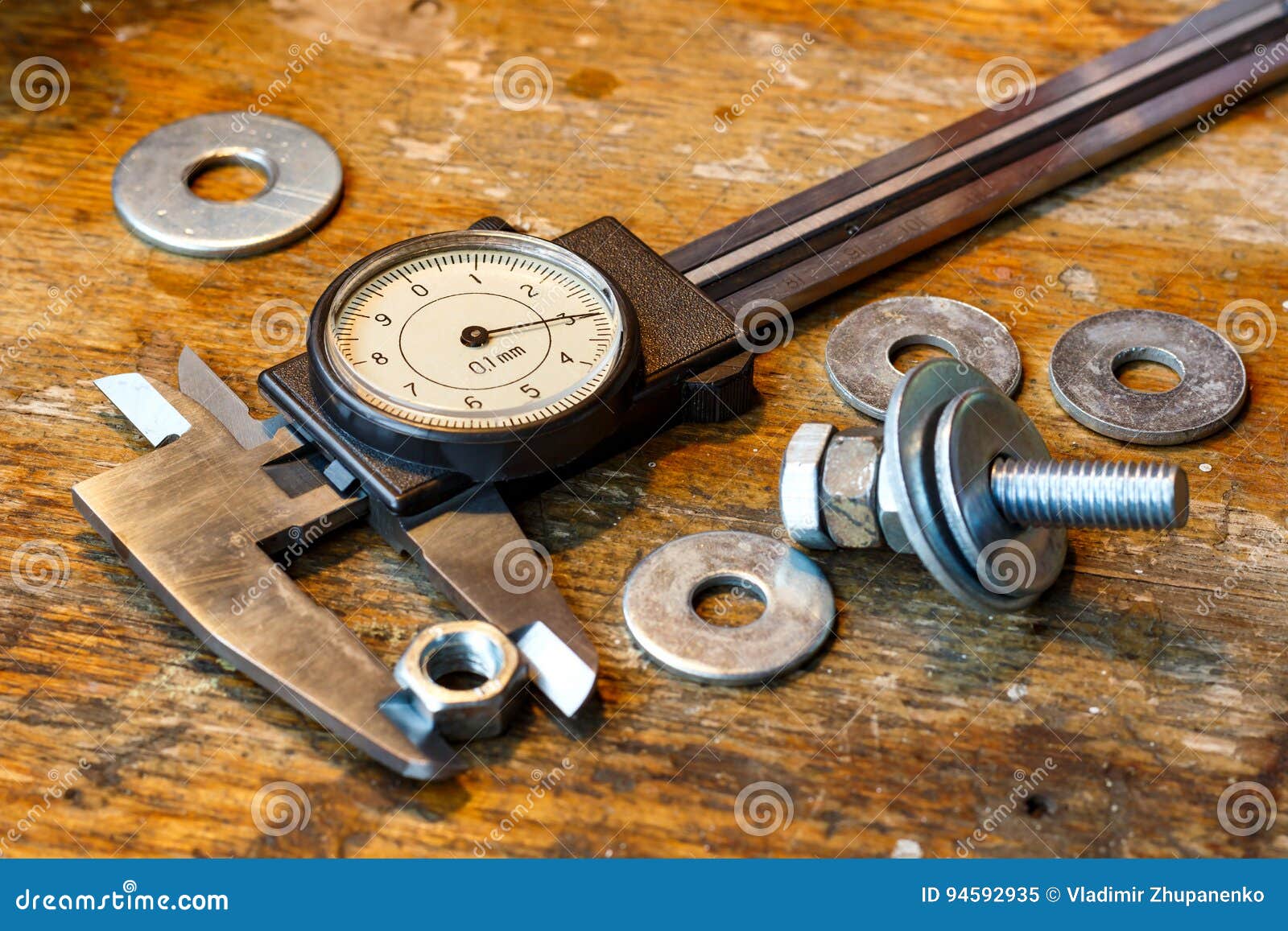 Slide Caliper with Round Scale and Bolt with Nuts on the Workbench in ...
