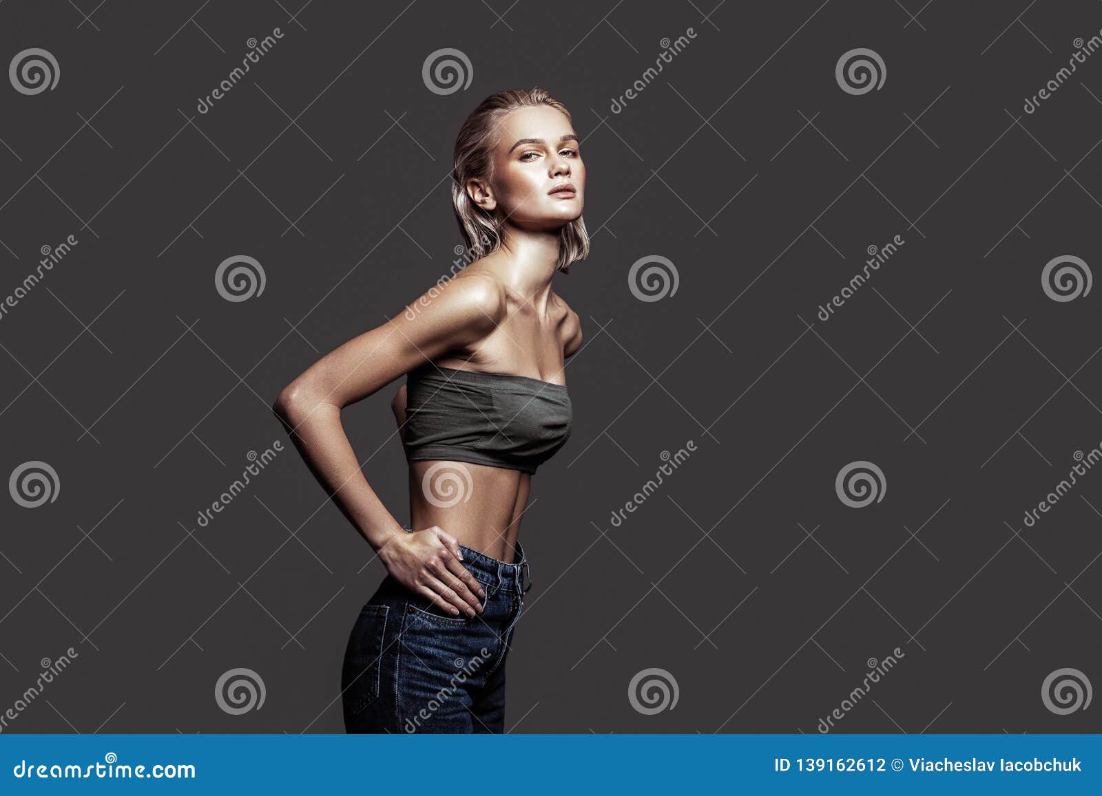 Slim Blonde-haired Model Standing Sideways while Posing Stock Photo ...
