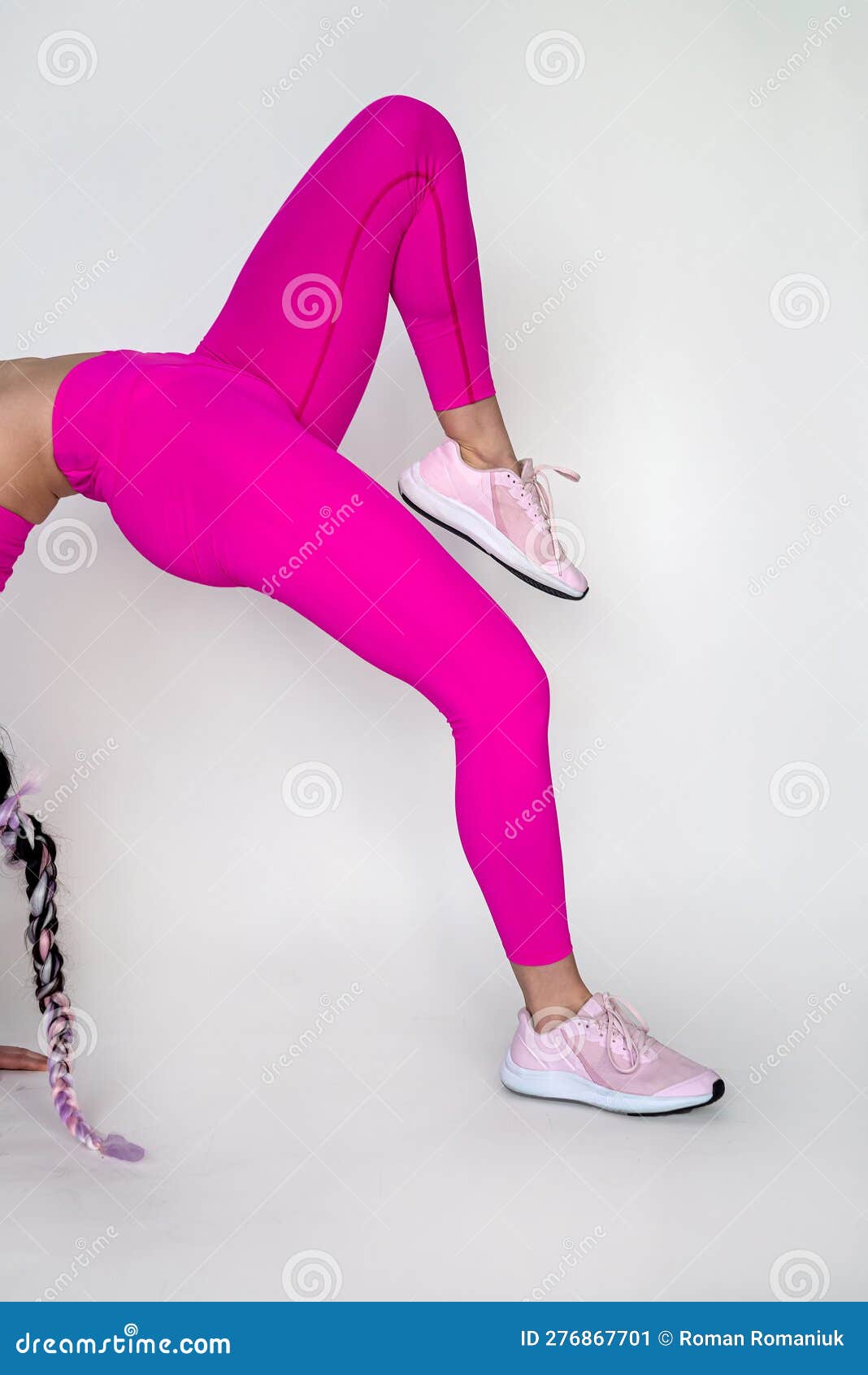 Slim Brunette Doing Yoga And Stretching Exercises In Crimson Leggings Isolated On White Wall