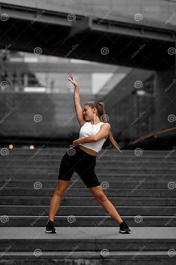Slim Female Athlete With Long Hair Doing Gymnastic Exercises With Legs