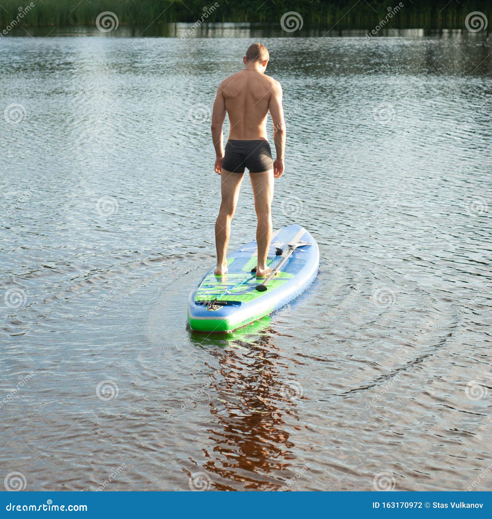 Slim Guy on the Sup Board. the View from the Back Stock Photo - Image ...