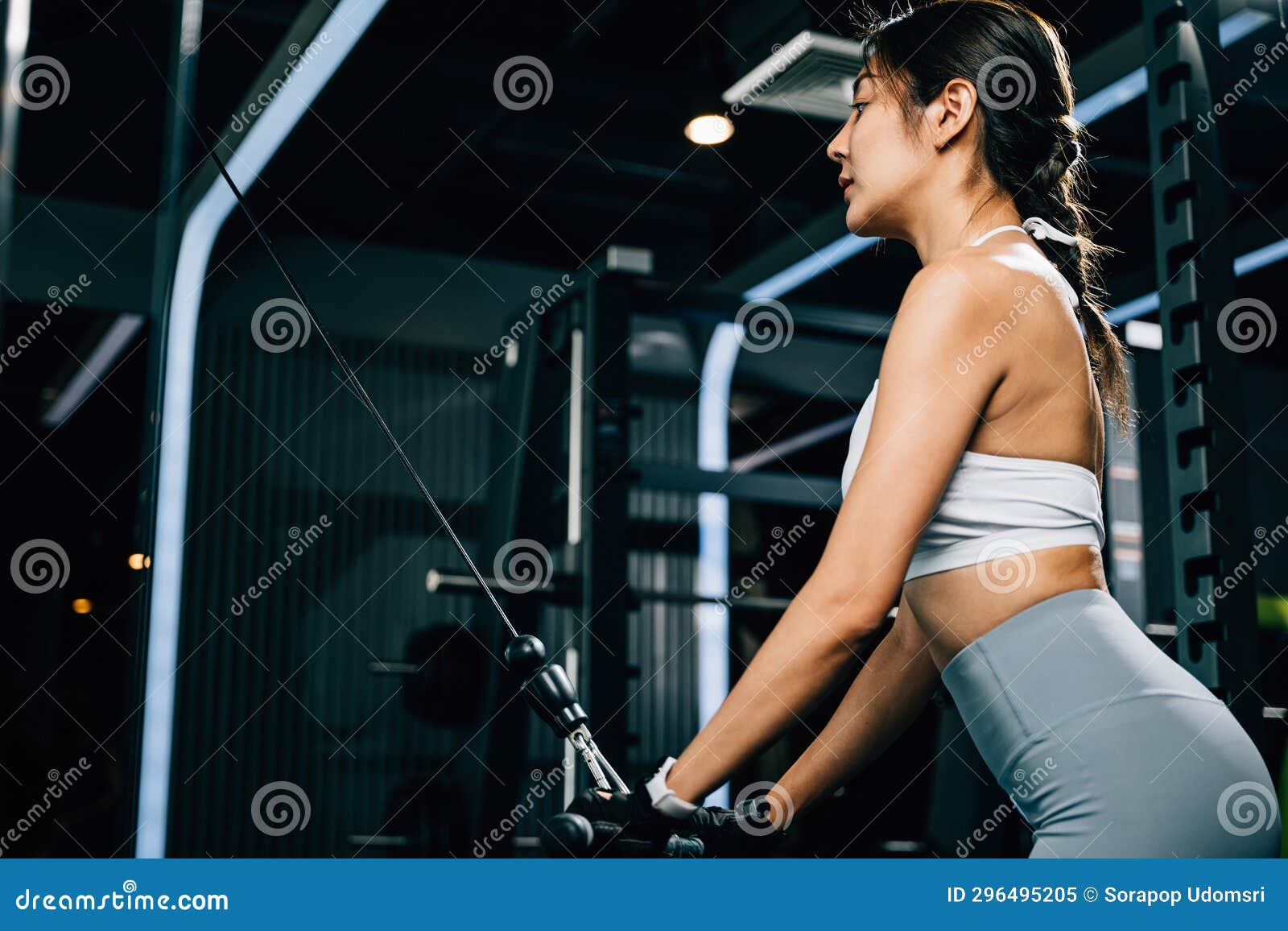 Slim and Strong Young Woman Working Out on a Pull-down Weight Machine ...