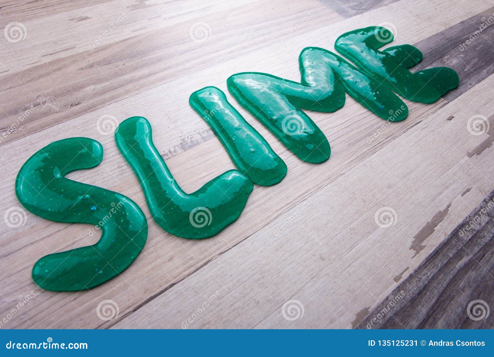 Slime Text Made from Transparent Slime Diagonally on a Wooden Surface ...