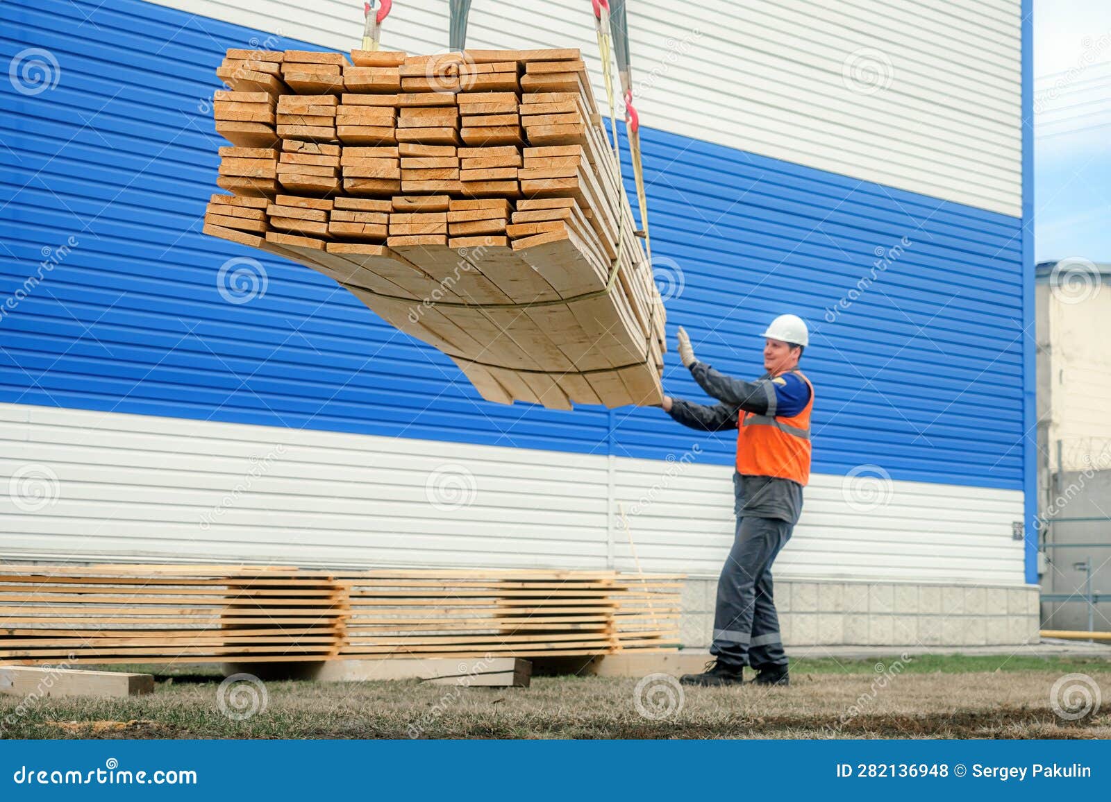 Slinger Worker Unloads Wooden Boards in Stack. Sale of Timber for ...