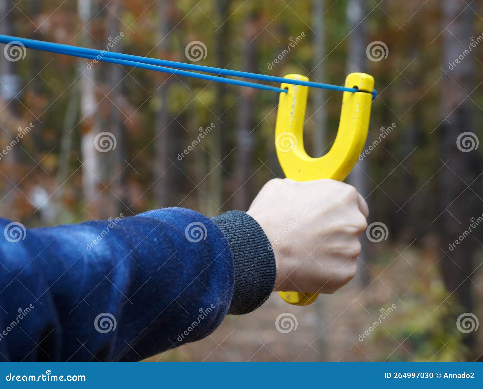 Slingshot with a Stretched Bowstring in a Female Hand Against the ...