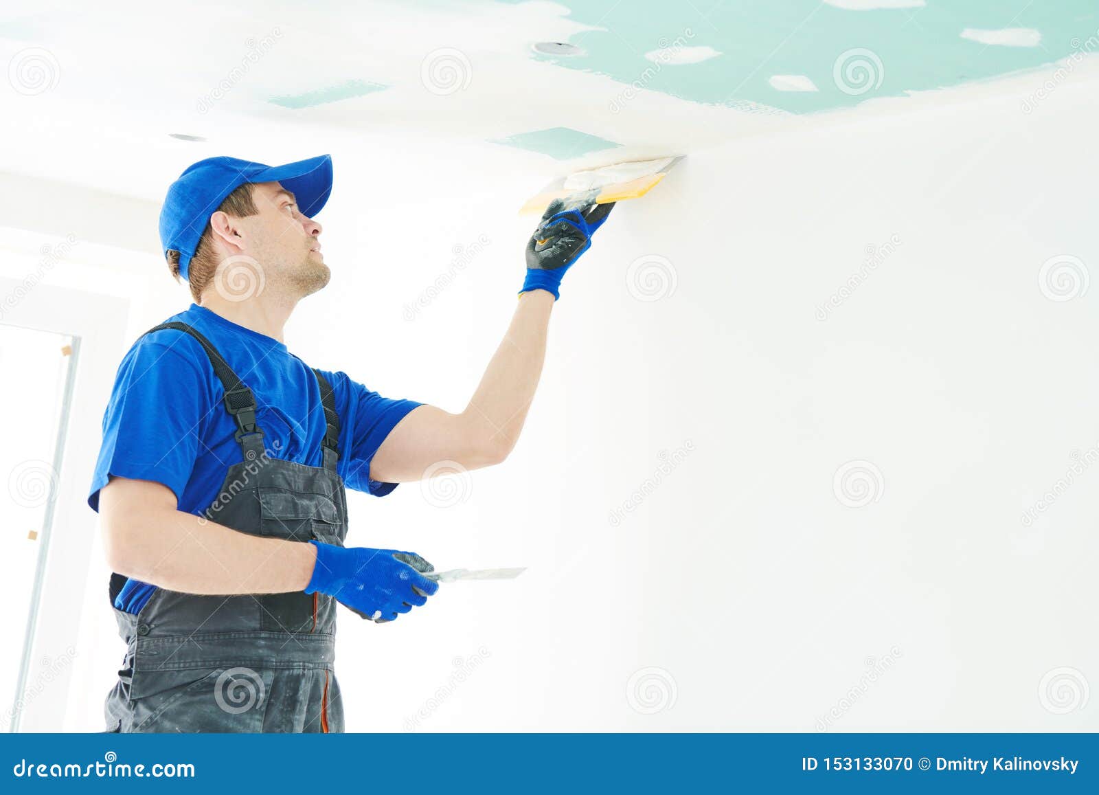 Refurbishment. Plasterer Spackling a Gypsum Plasterboard Ceiling with ...