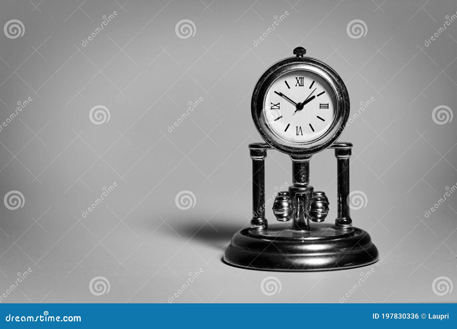 A Small Analog Clock with Roman Numerals on Its Dial Stock Photo ...