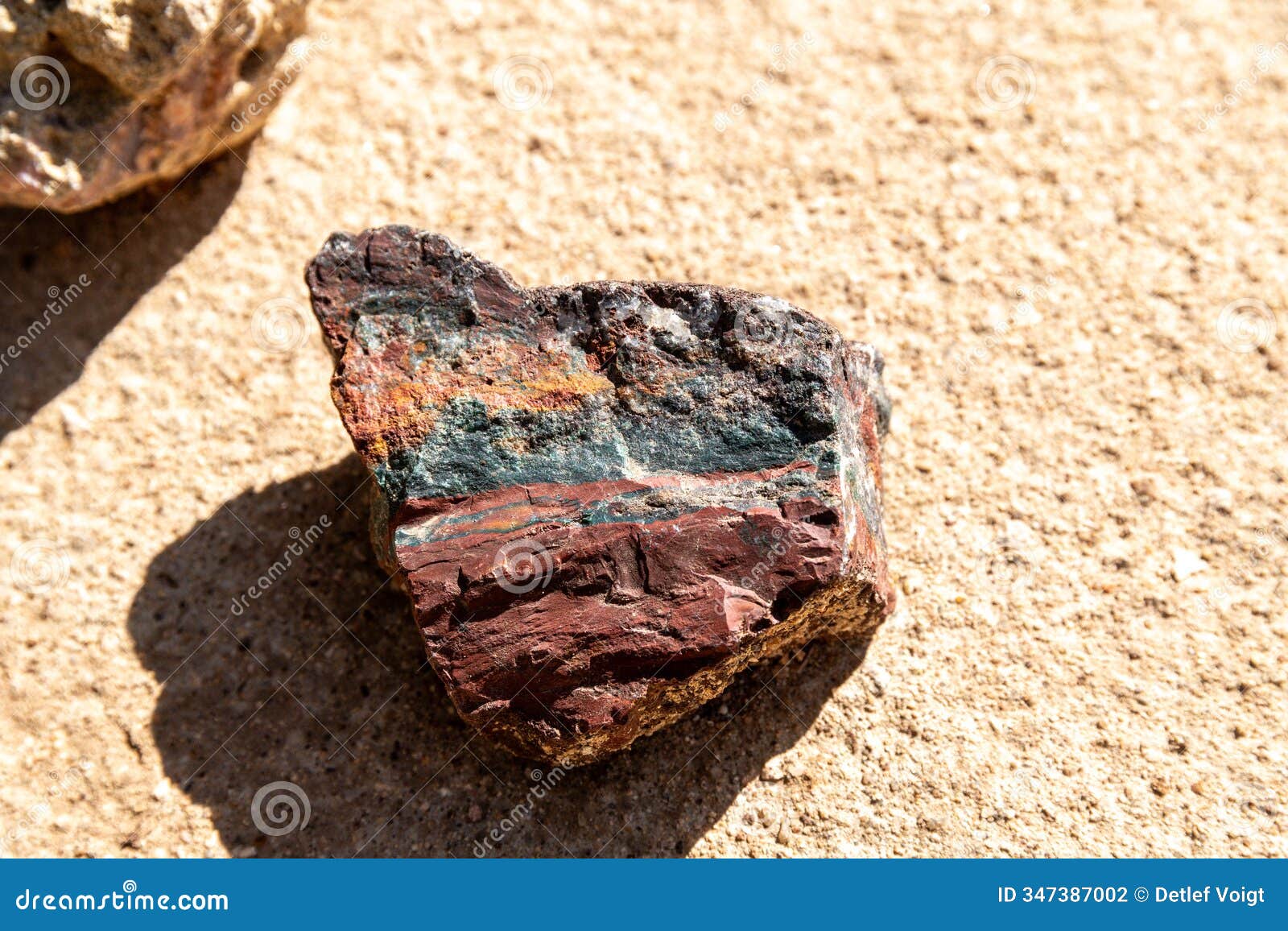 Small Angular Stone with Intense Red, Orange, and Green Colors on Sandy ...