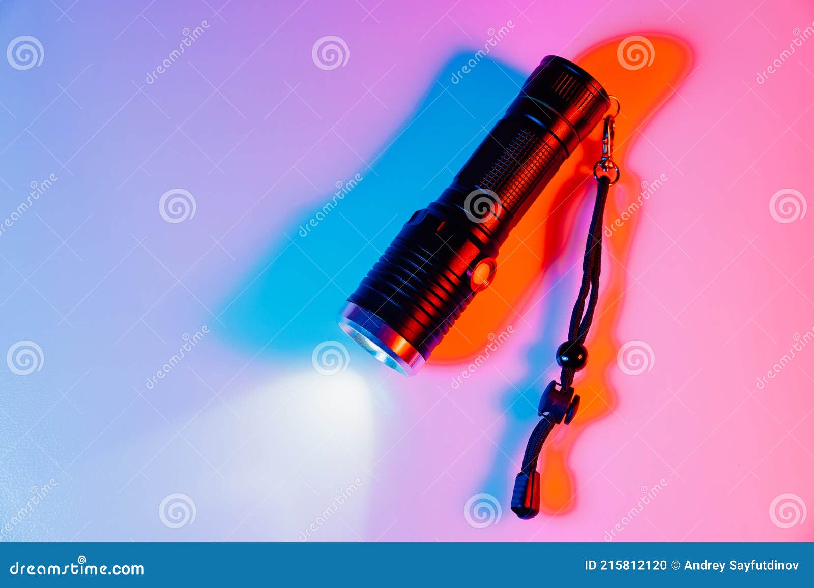 A Small Black Flashlight in Colored Lighting. Stock Photo - Image of ...