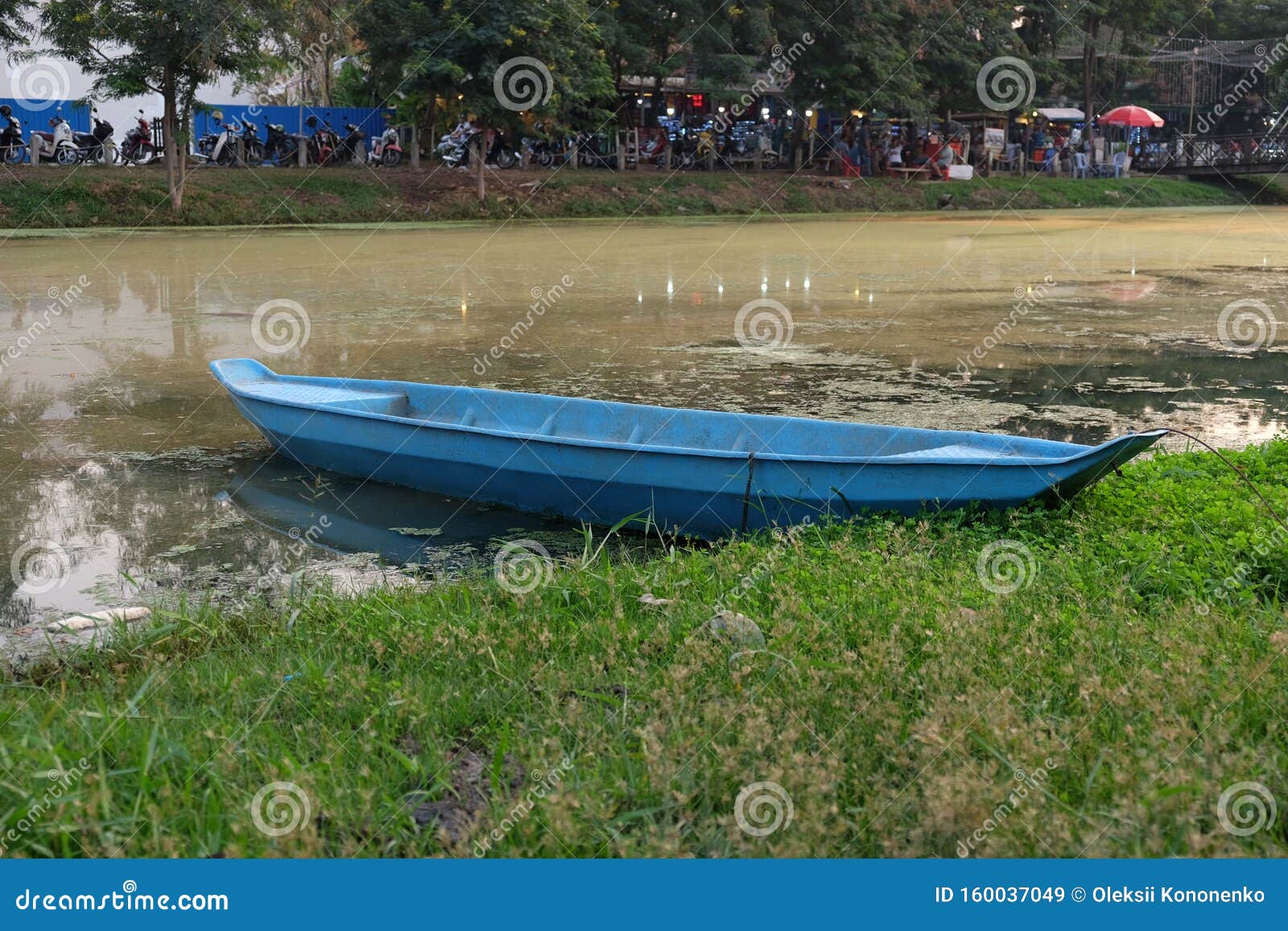 A Small Blue Boat by the River. a River with Muddy Waters Editorial ...