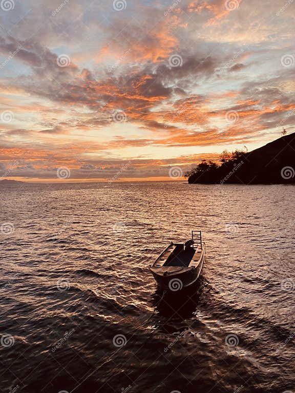 A Small Boat in the Middle of a Lake at Sunset Stock Image - Image of ...