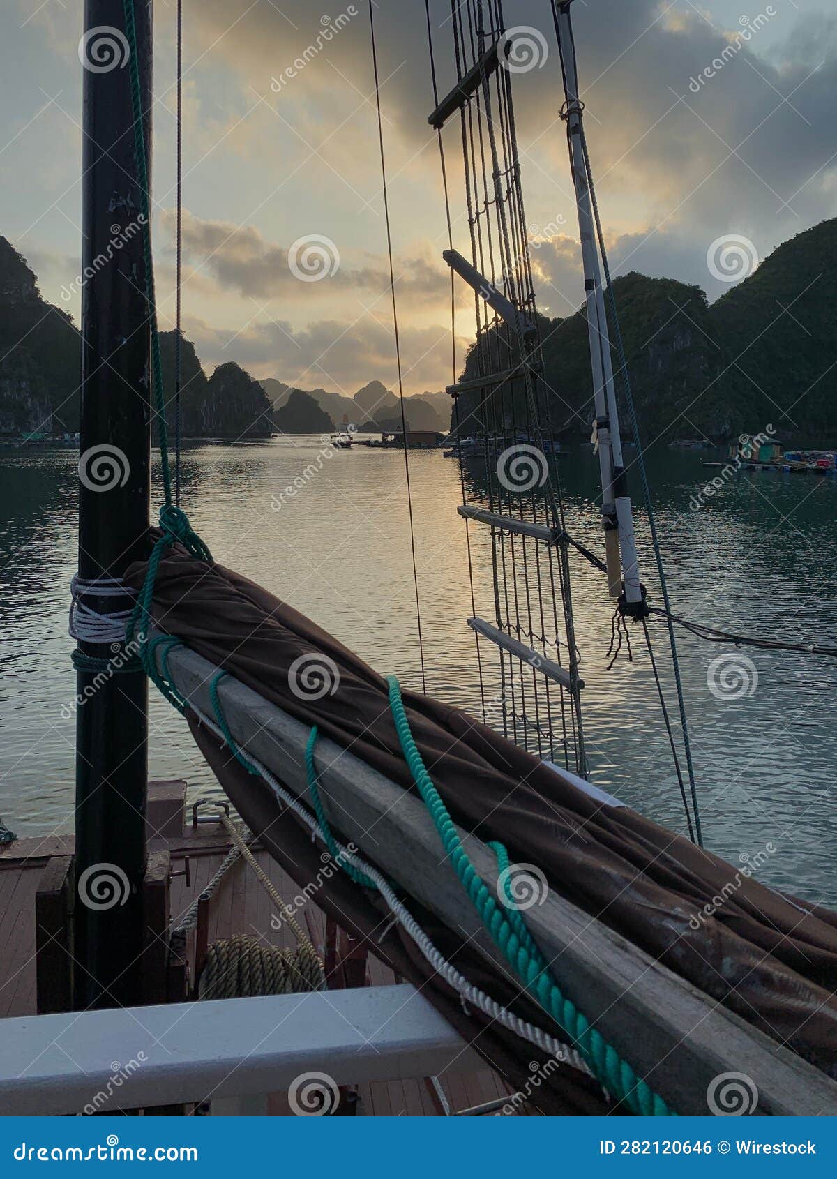 Small Boat Sailing on a Tranquil Body of Water, with the Sun Setting in ...