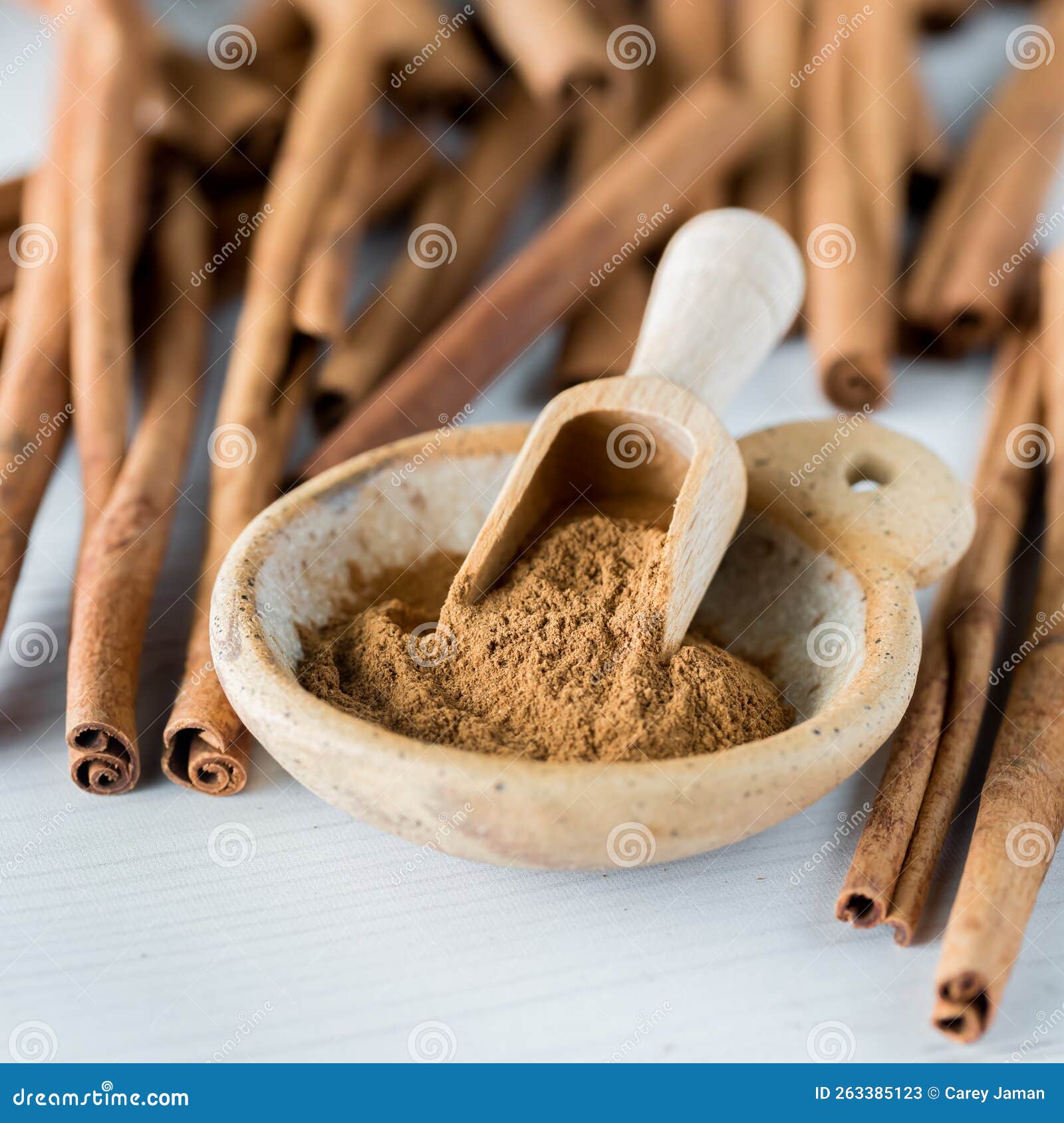 A Small Bowl of Cinnamon Powder with Cinnamon Sticks Scattered in ...