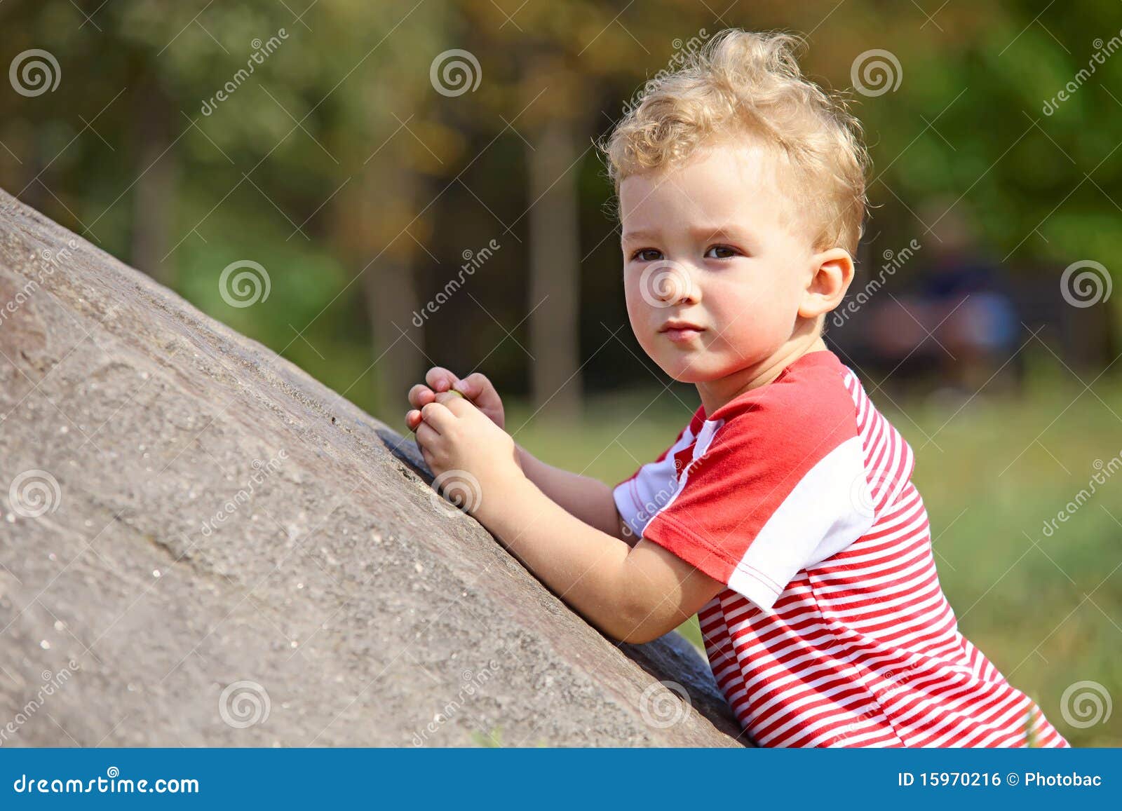Small Boy Leaning on a Rock in the Park Stock Photo - Image of life ...