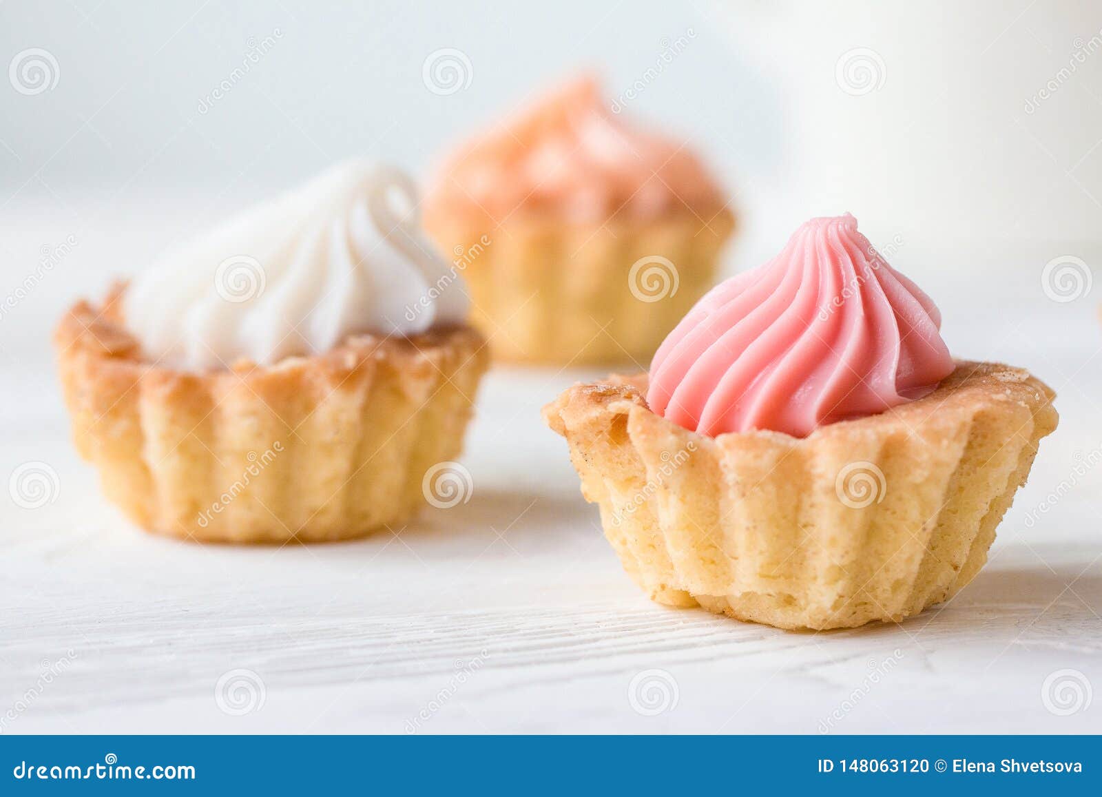 Small Cakes and with Cream on a White Table. Selective Focus. Stock ...