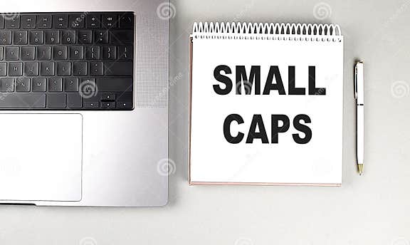 SMALL CAPS Text on Notebook with Laptop and Pen Stock Photo - Image of ...
