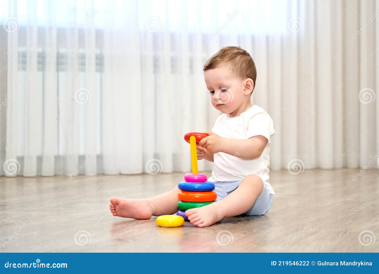 A Small Child with Blue Eyes is Playing in the Game Room. Stock Photo ...