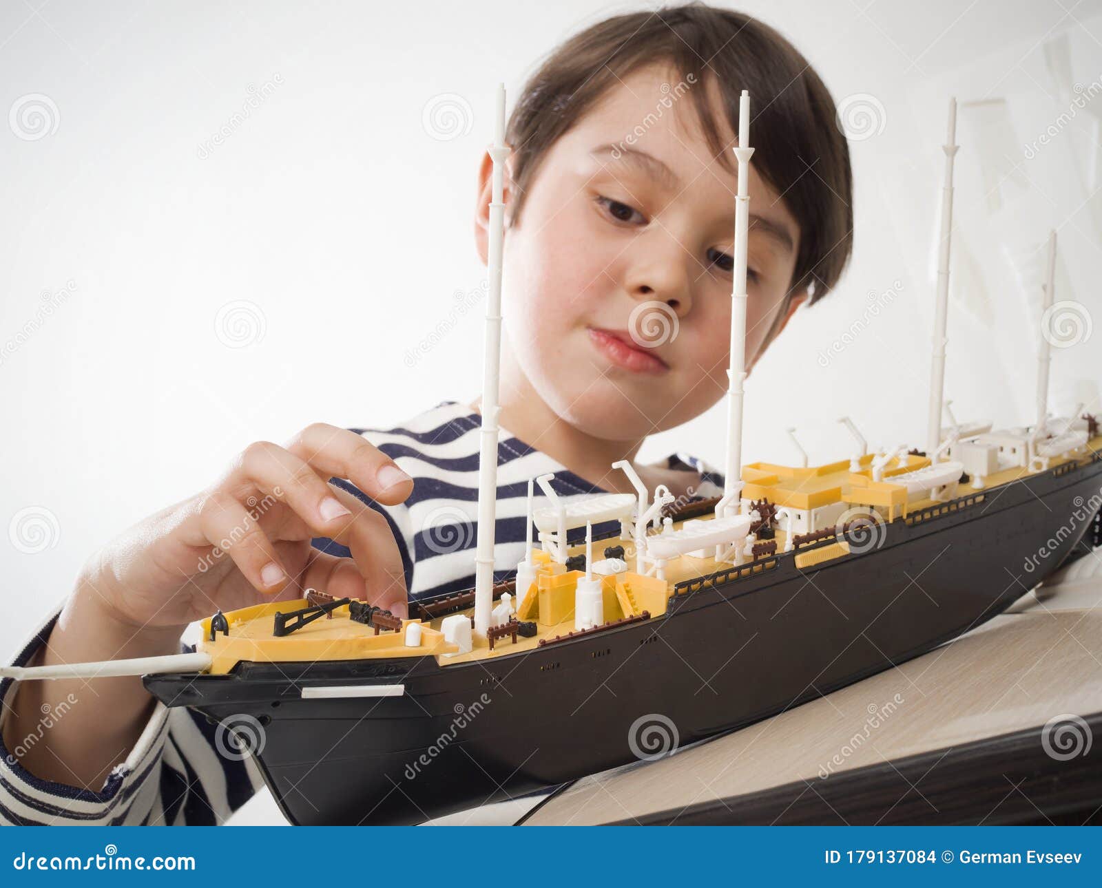A Small Child Builds a Model Ship Stock Photo - Image of garage ...