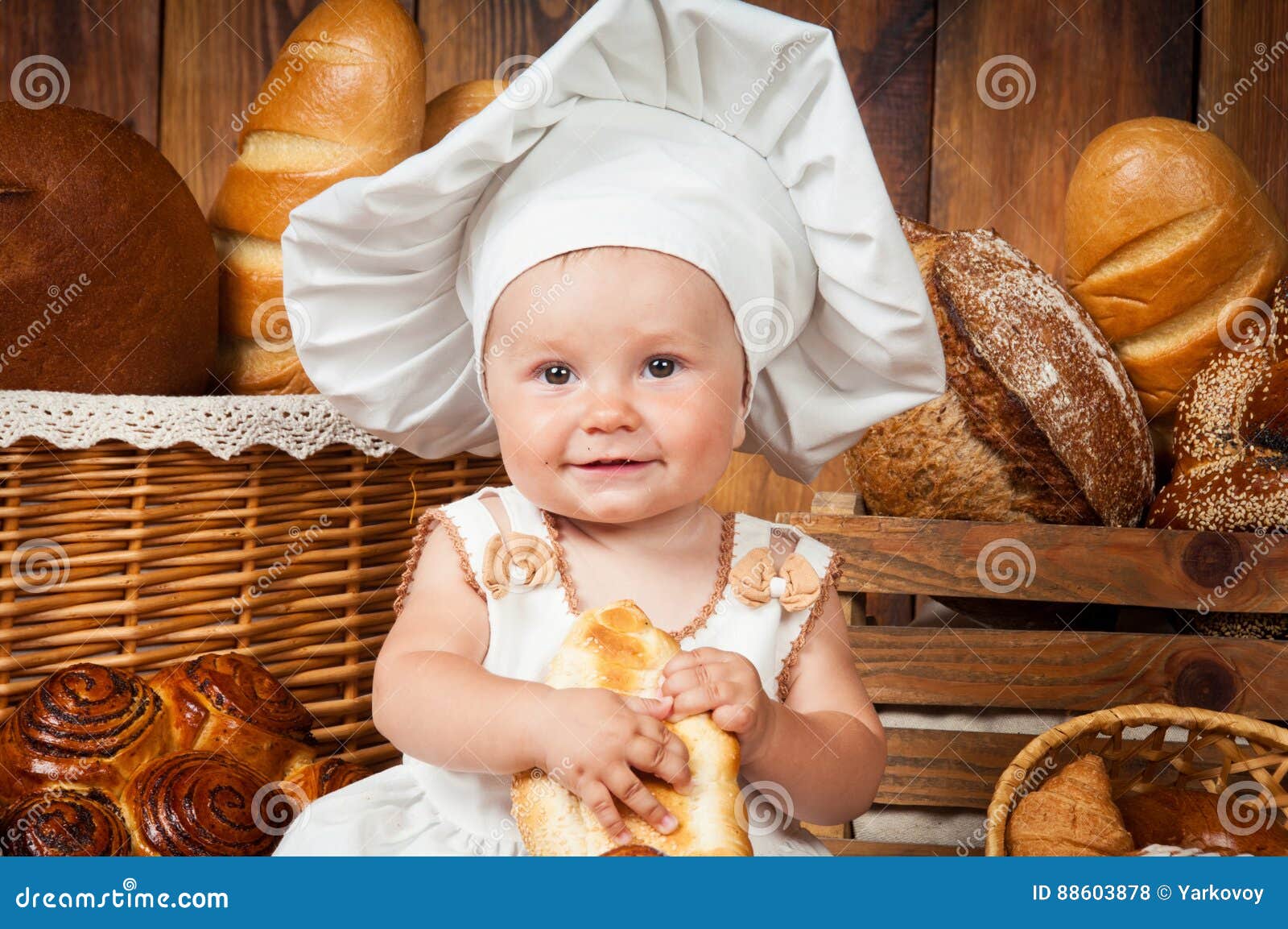 Small Child Cooks a Croissant in the Background of Baskets with Rolls ...