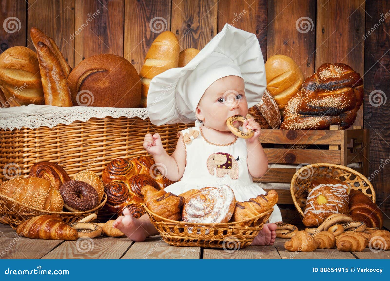 Small Child Cooks a Croissant in the Background of Baskets with Rolls ...