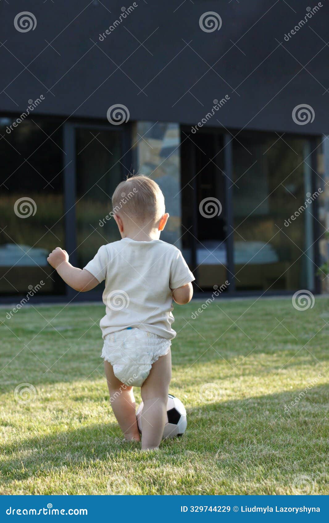A Small Child in a Diaper Plays with a Ball in the Yard Stock Image ...