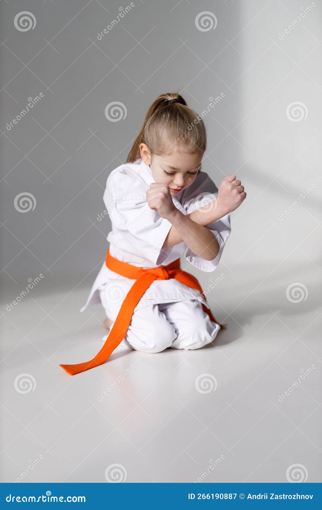 A Small Child is a Karate Student, Sitting Position on a White ...