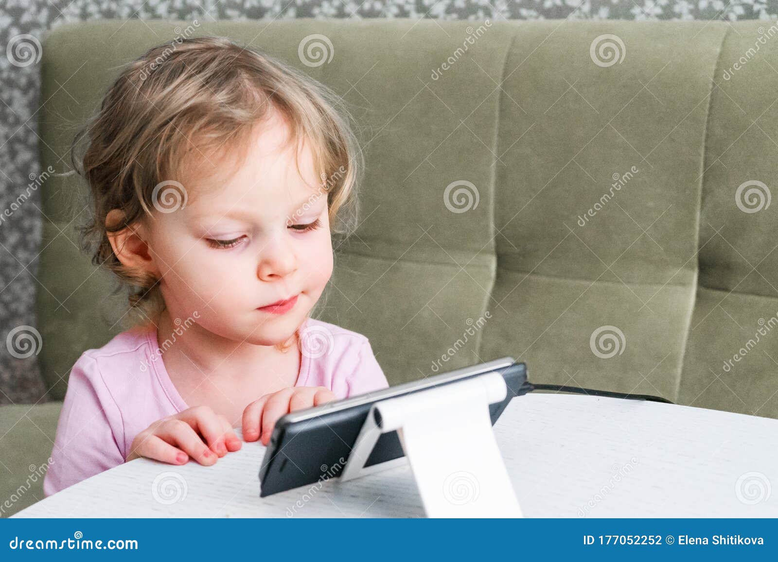 A Small Child is Looking at the Phone Stock Photo - Image of european ...