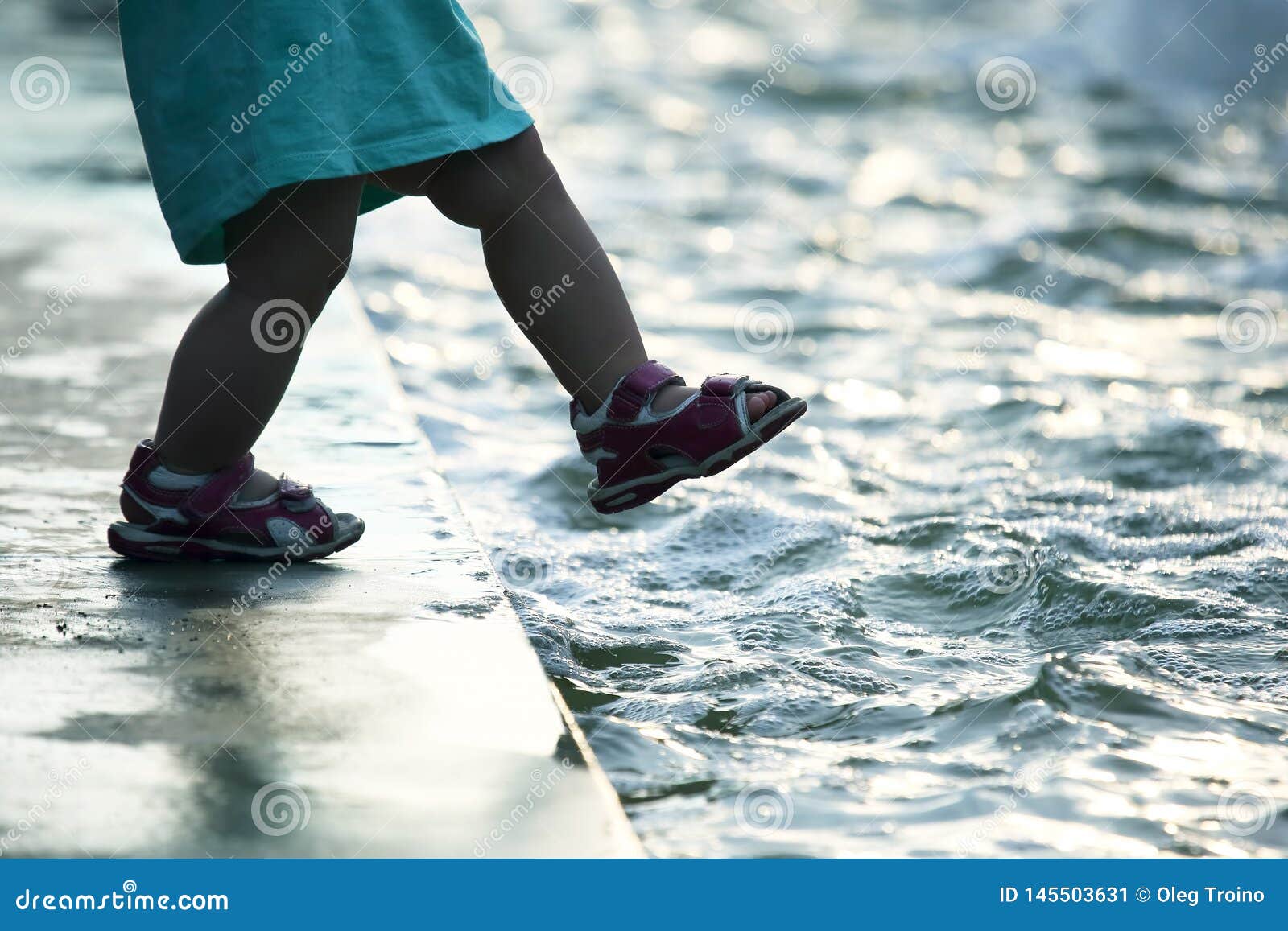 Small Child on the Pavement Makes a Dangerous Step into the Water Stock ...