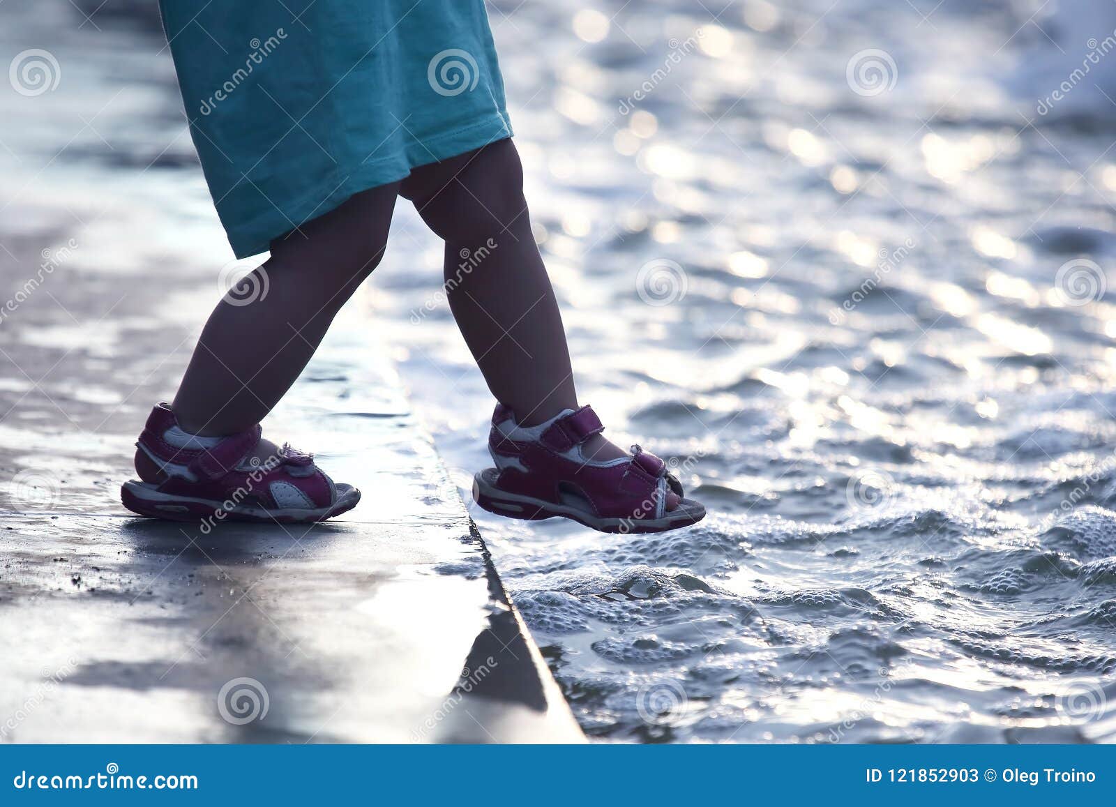 Small Child on the Pavement Makes a Dangerous Step into the Water Stock ...