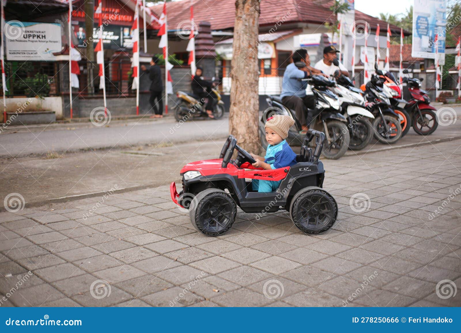 A Small Child is Riding in a Mini Car Which is Controlled by Using a ...