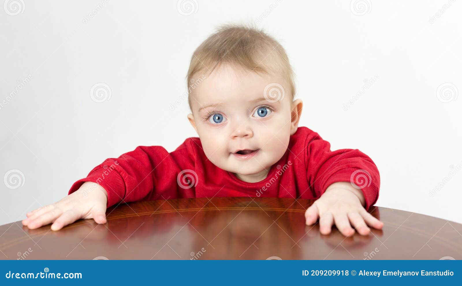 A Small Child Stands with His Hands on the Table Stock Photo - Image of ...